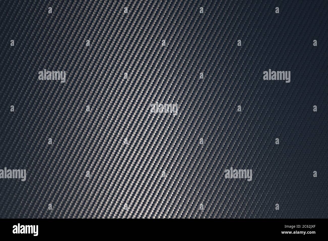 Grey woven carbon fibre sheet surface with light reflection. Texture ...