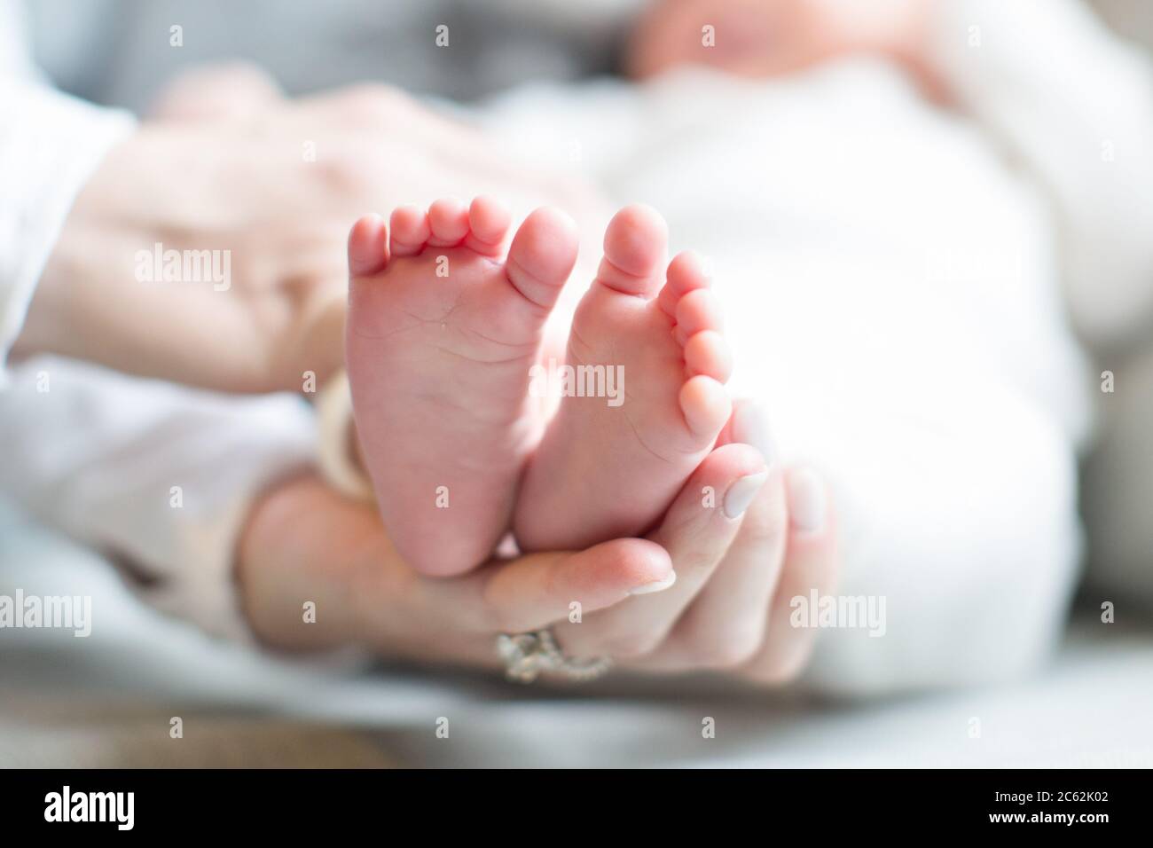Close up of baby feet being held by mother's hand Stock Photo - Alamy