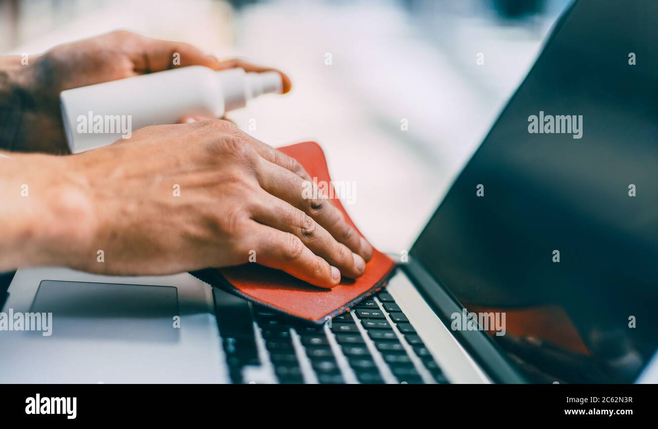 close up. man spraying spray on the surface of a laptop Stock Photo - Alamy