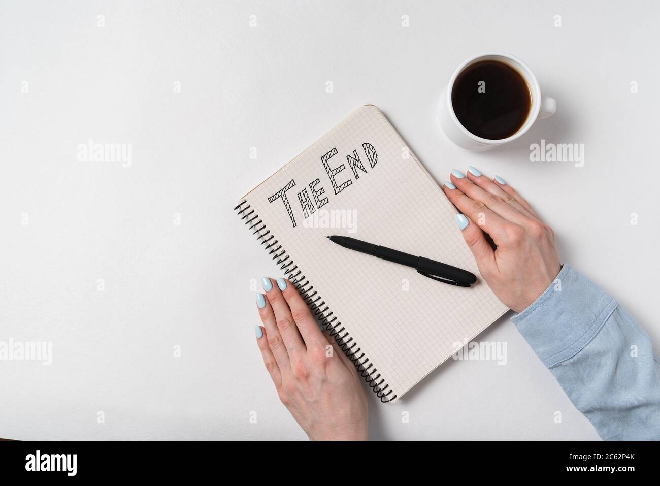 The End notice on notepad, woman hand, Notebook and cup of coffee on ...