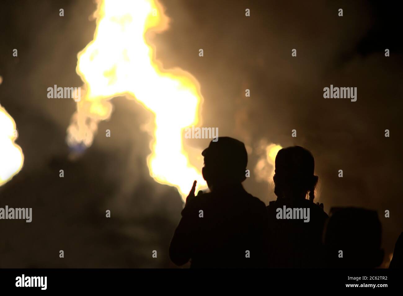 silhouettes of children on the background of fire fire. Children ...