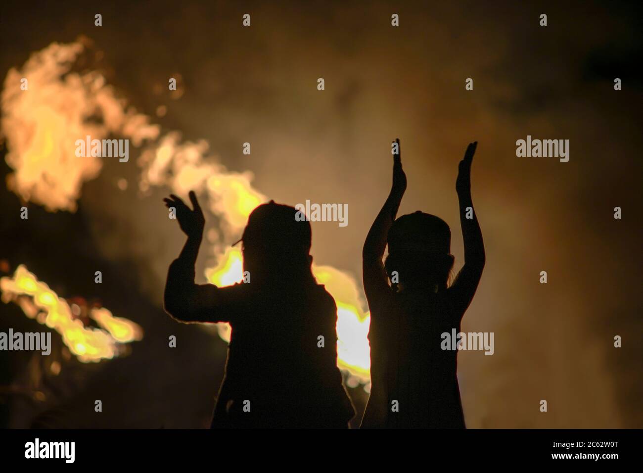 silhouettes of children on the background of fire fire. Children ...