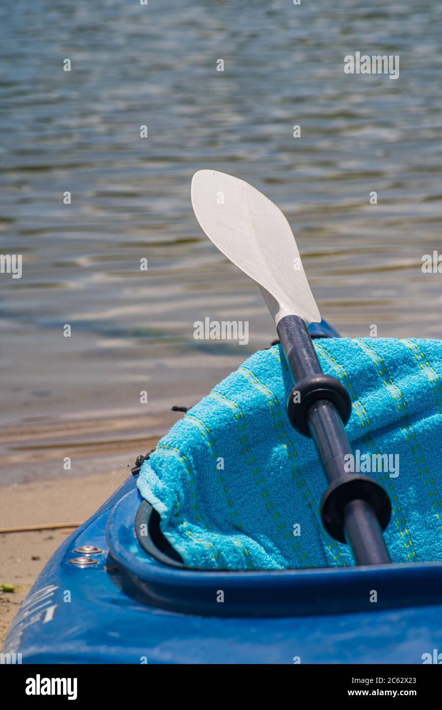 Empty kayak with paddle on lakeshore Stock Photo - Alamy