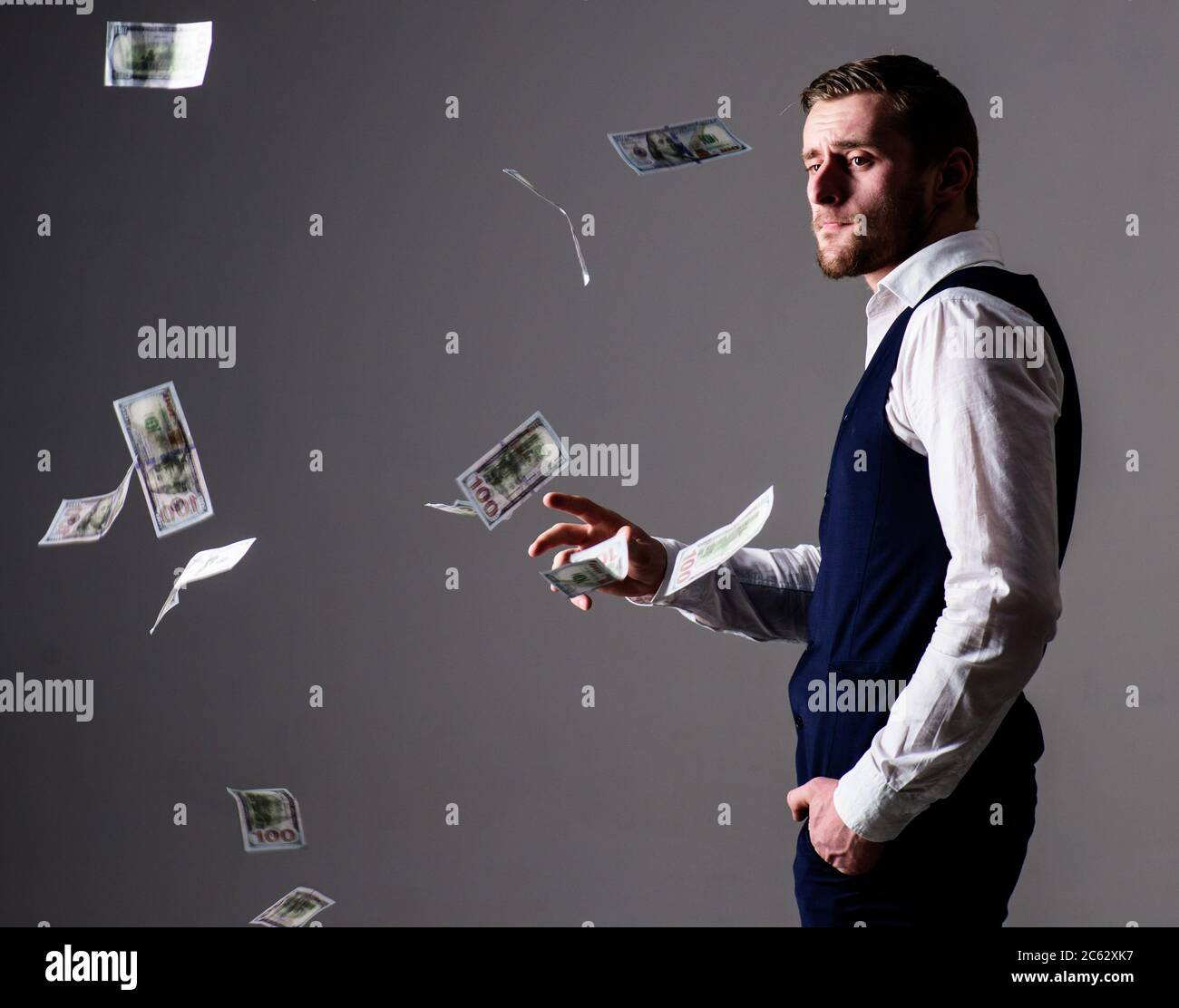Man in formal wear, businessman throwing money on grey background ...