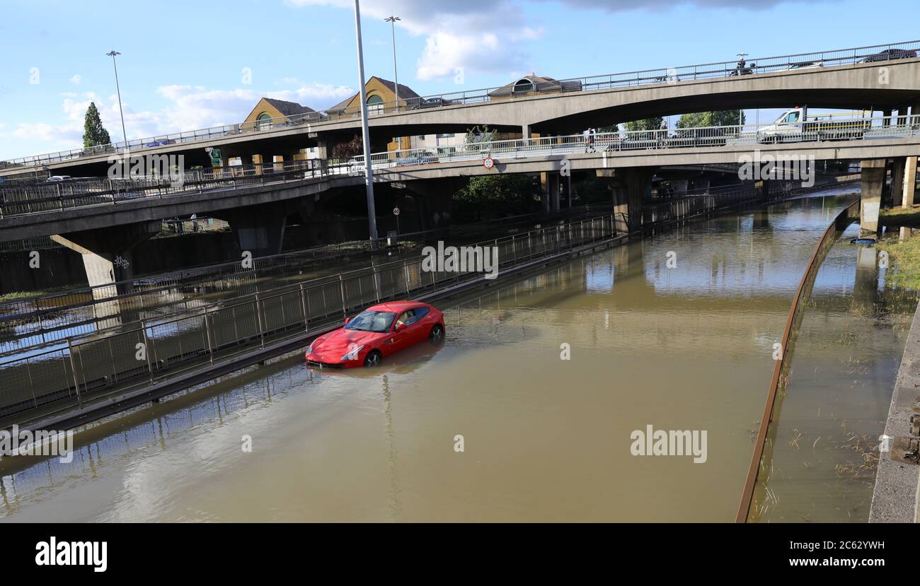 An abandoned Ferrari FF car in flood water on the North Circular road ...