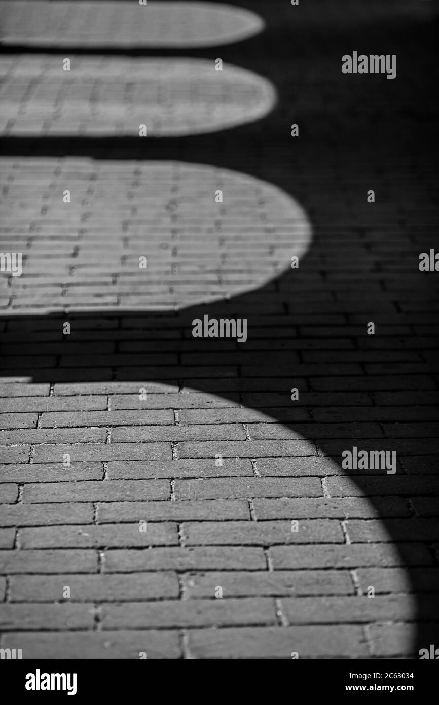 curved shadows on a paved path Stock Photo - Alamy