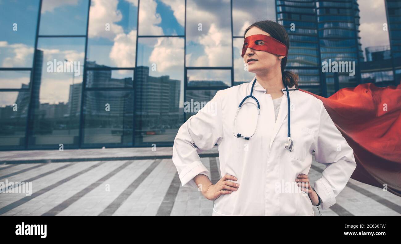 female paramedic in a superhero raincoat standing on a city street ...