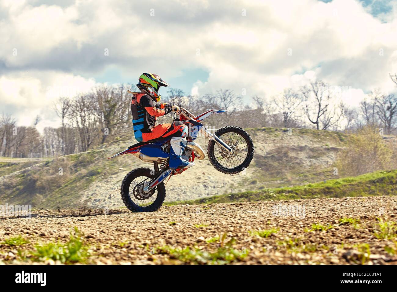 Motocross driver in action accelerating the motorbike takes off and ...