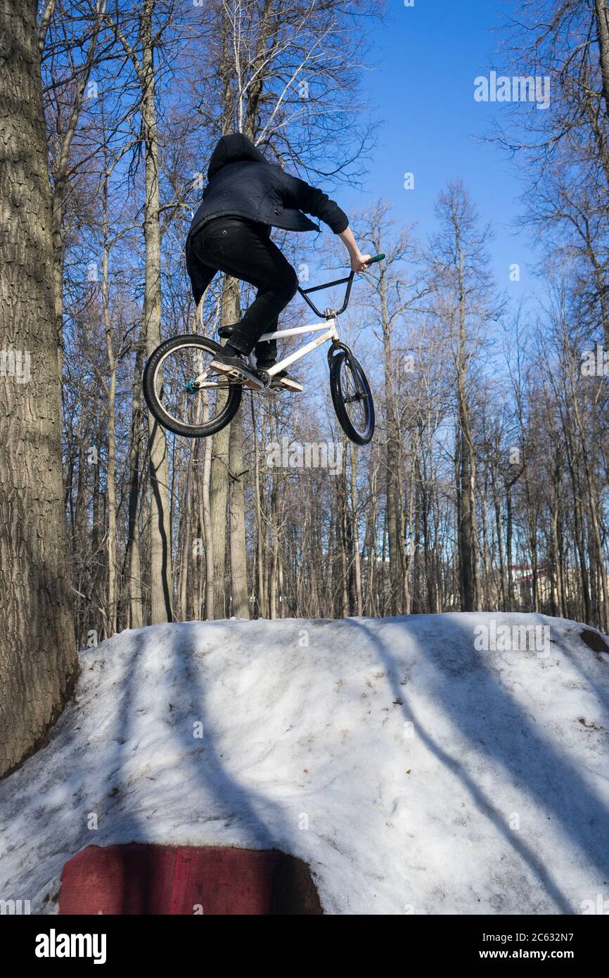 bmx rider does a dirt jumping trick in the winter. Moto whip on bmx ...