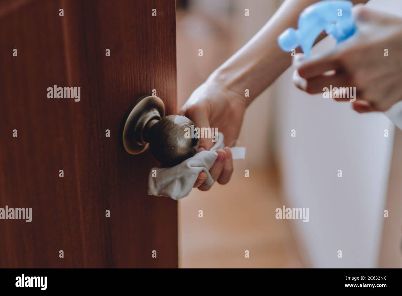 Woman cleans the door handle with an antibacterial spray Stock Photo ...