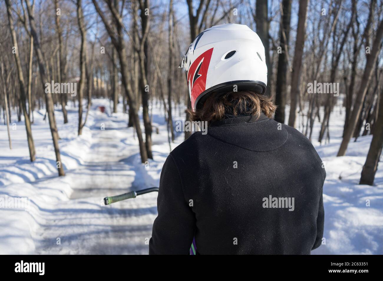 a cyclist in a helmet stands with his back. Rider getting ready to do ...