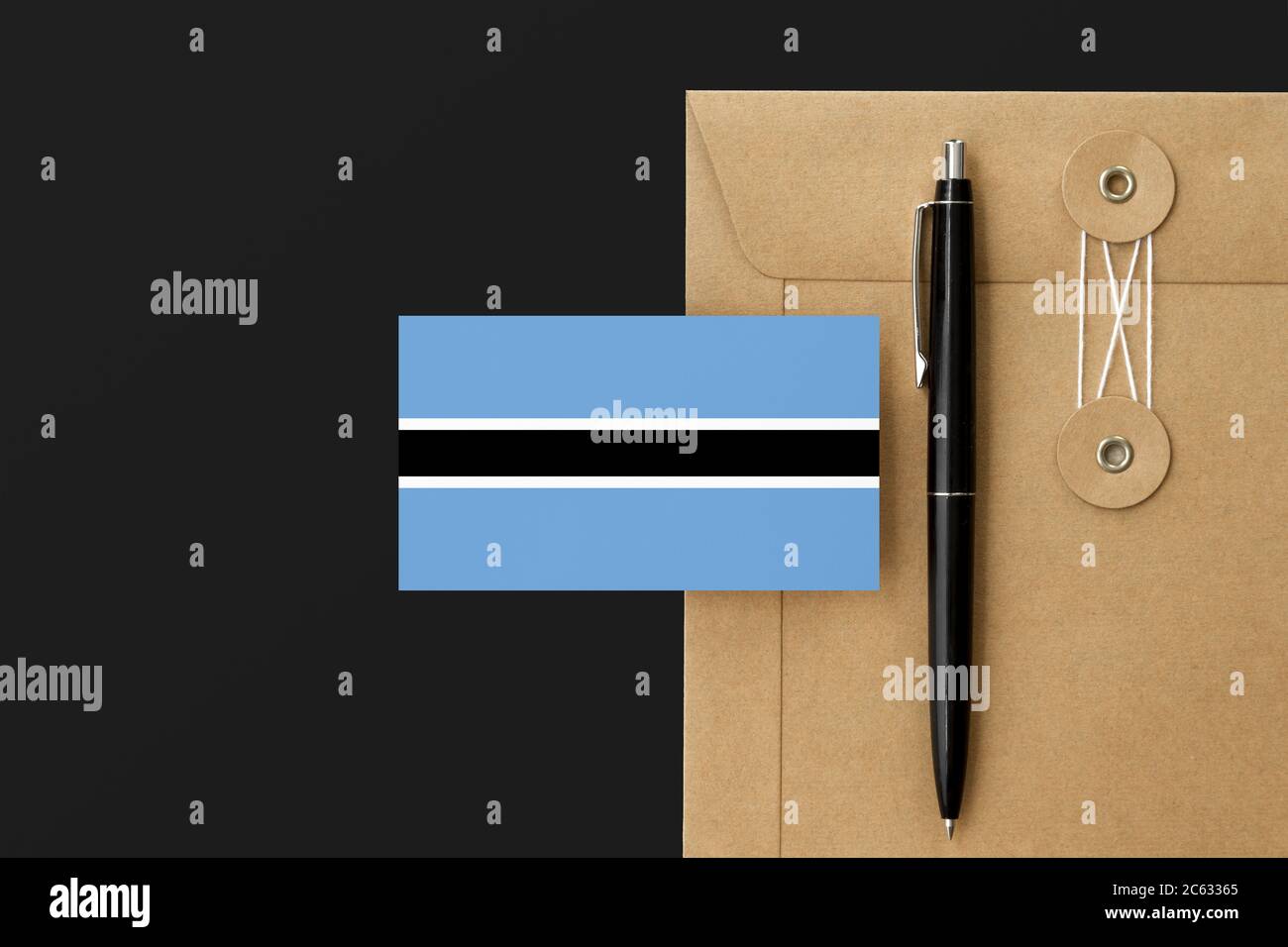 Botswana flag on craft envelope letter and black pen background ...