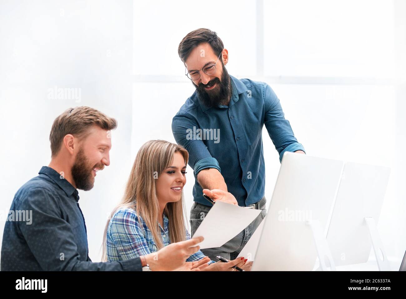 employees discussing business documents at the Desk Stock Photo - Alamy