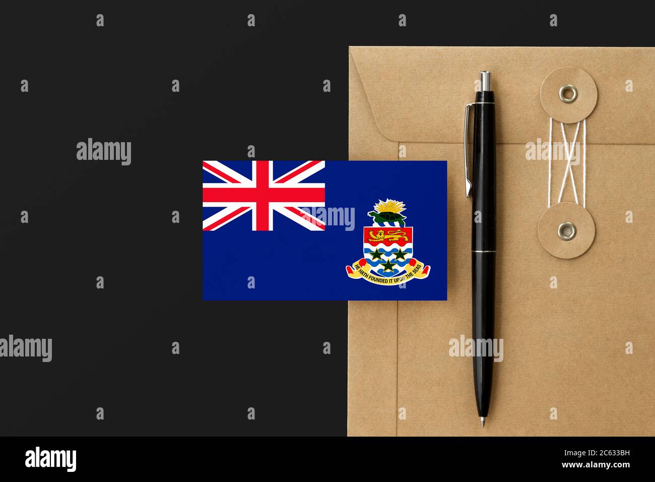 Cayman Islands flag on craft envelope letter and black pen background ...