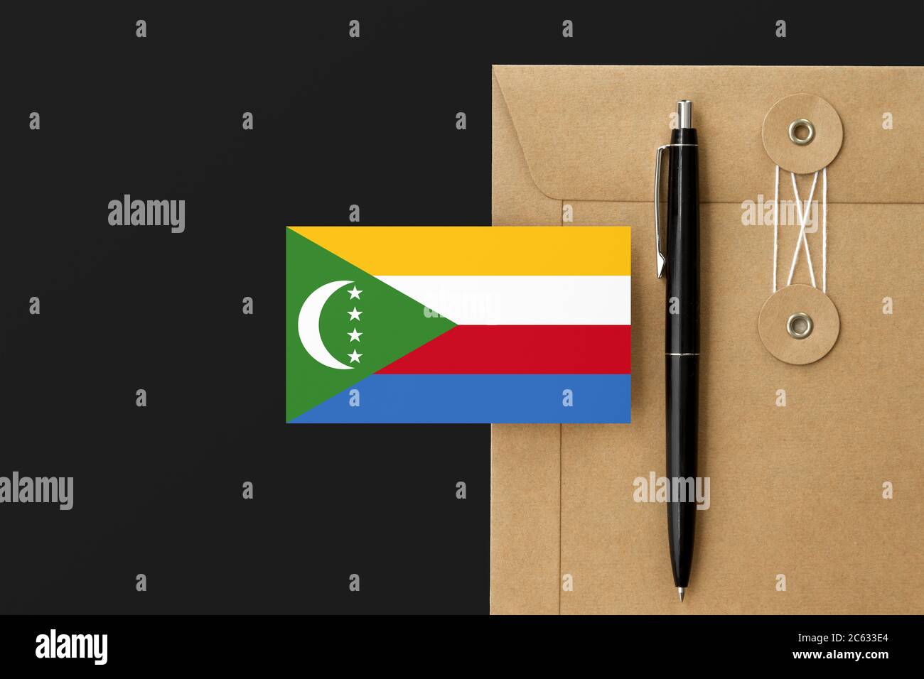 Comoros flag on craft envelope letter and black pen background ...