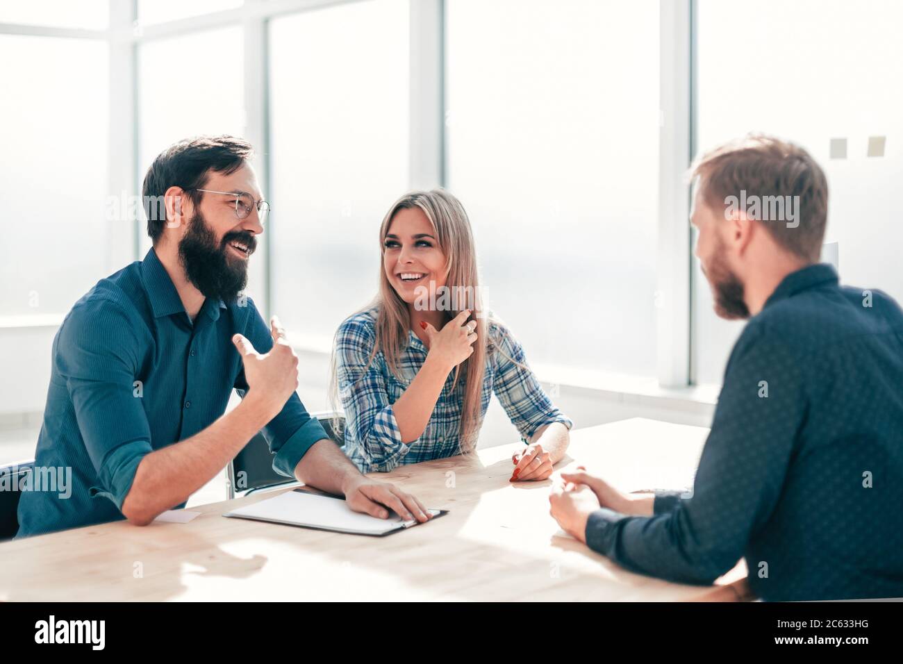 group of successful young people sitting at the negotiating table Stock ...