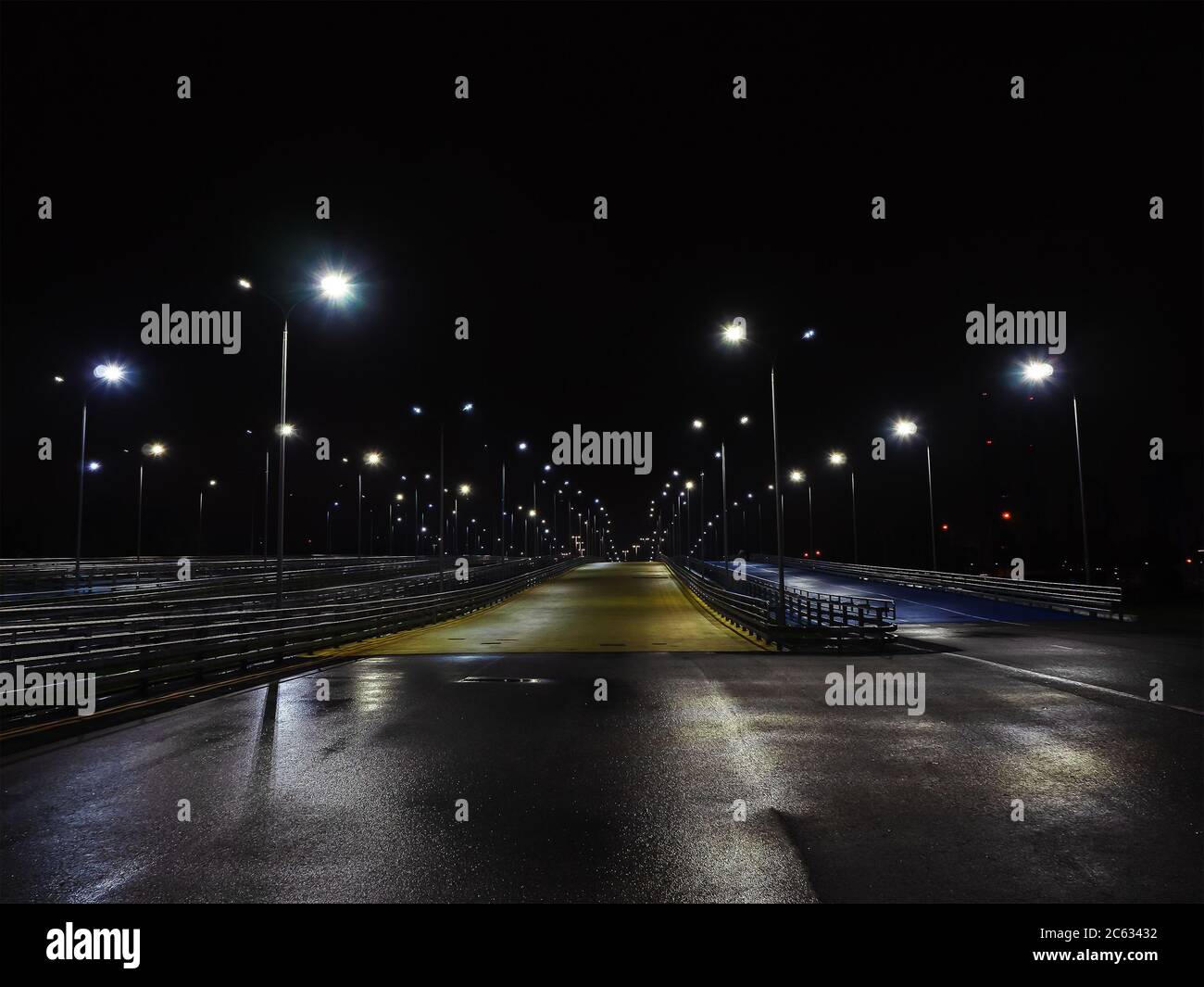 Night view of the roads going into the distance, with fences on the ...