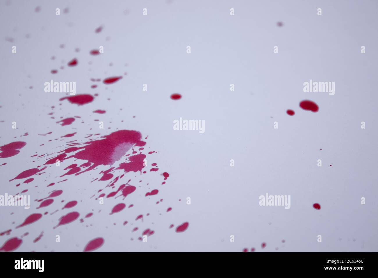 drops of red liquid - blood - on a white paper. Copy space. High ...