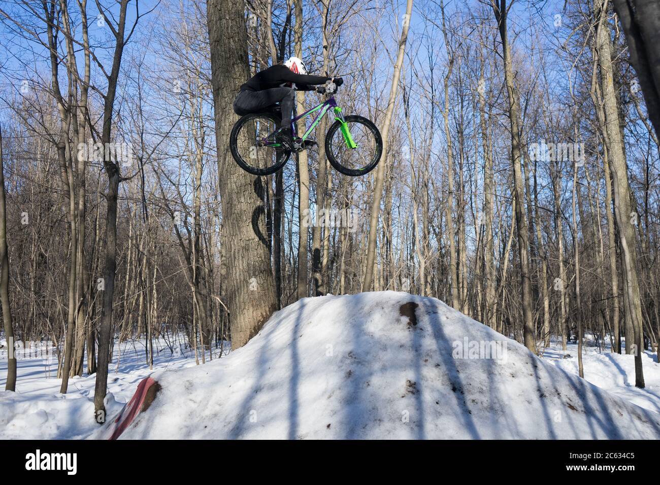 Rider jumps on a bicycle in winter dirt jumping. Cyclist doing a trick ...