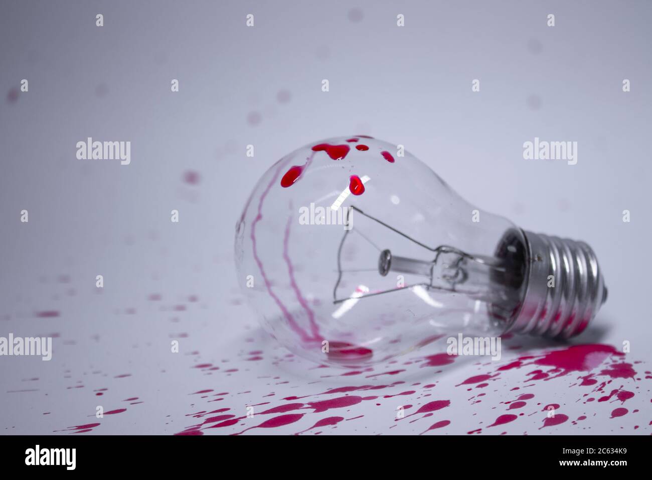 light bulb stained with red liquid - blood - on a white background in ...