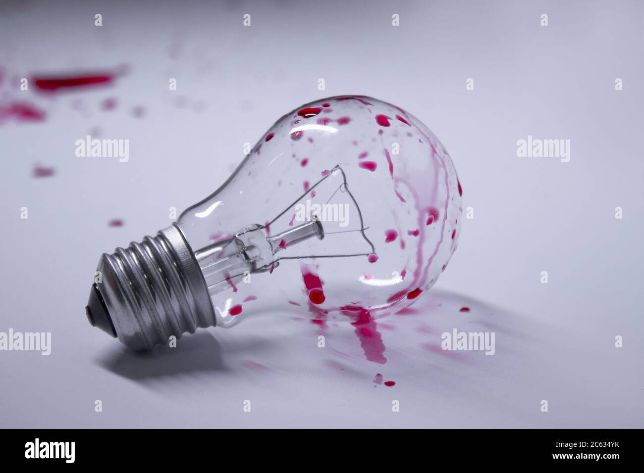 light bulb stained with red liquid - blood - on a white background in ...