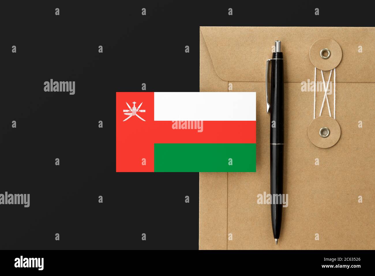 Oman flag on craft envelope letter and black pen background. National ...