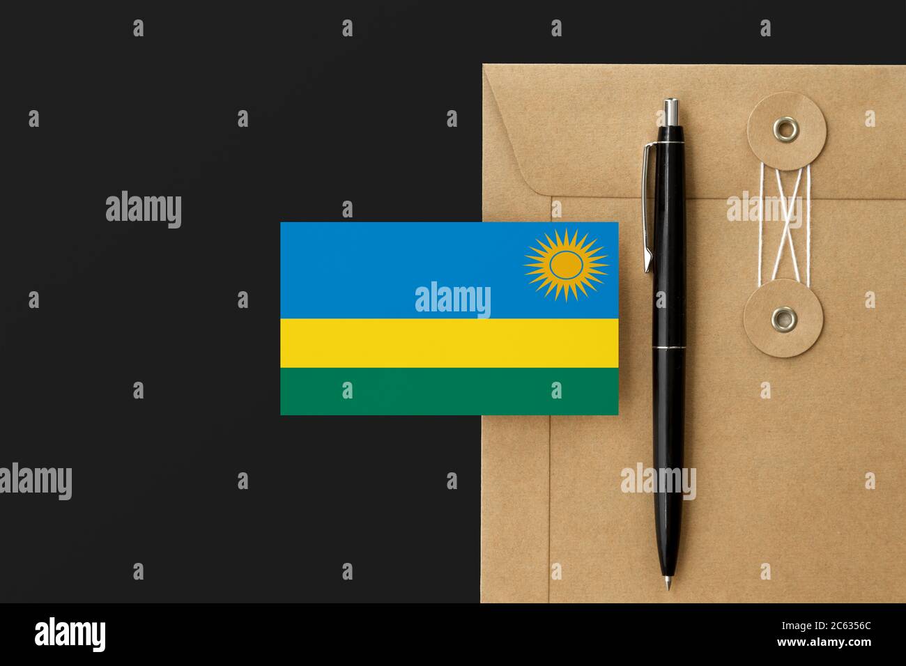 Rwanda flag on craft envelope letter and black pen background. National ...