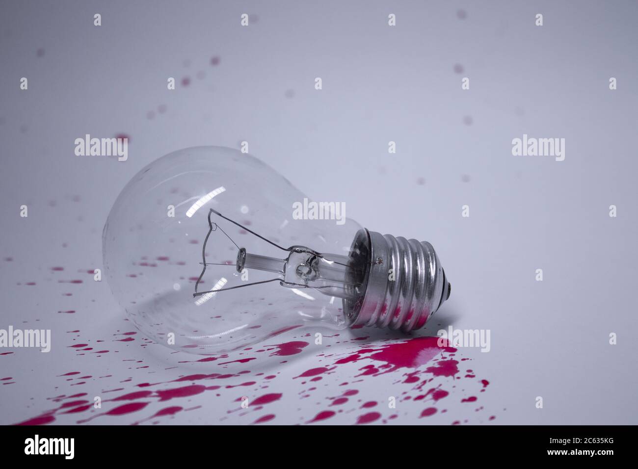 light bulb stained with red liquid - blood - on a white background in ...