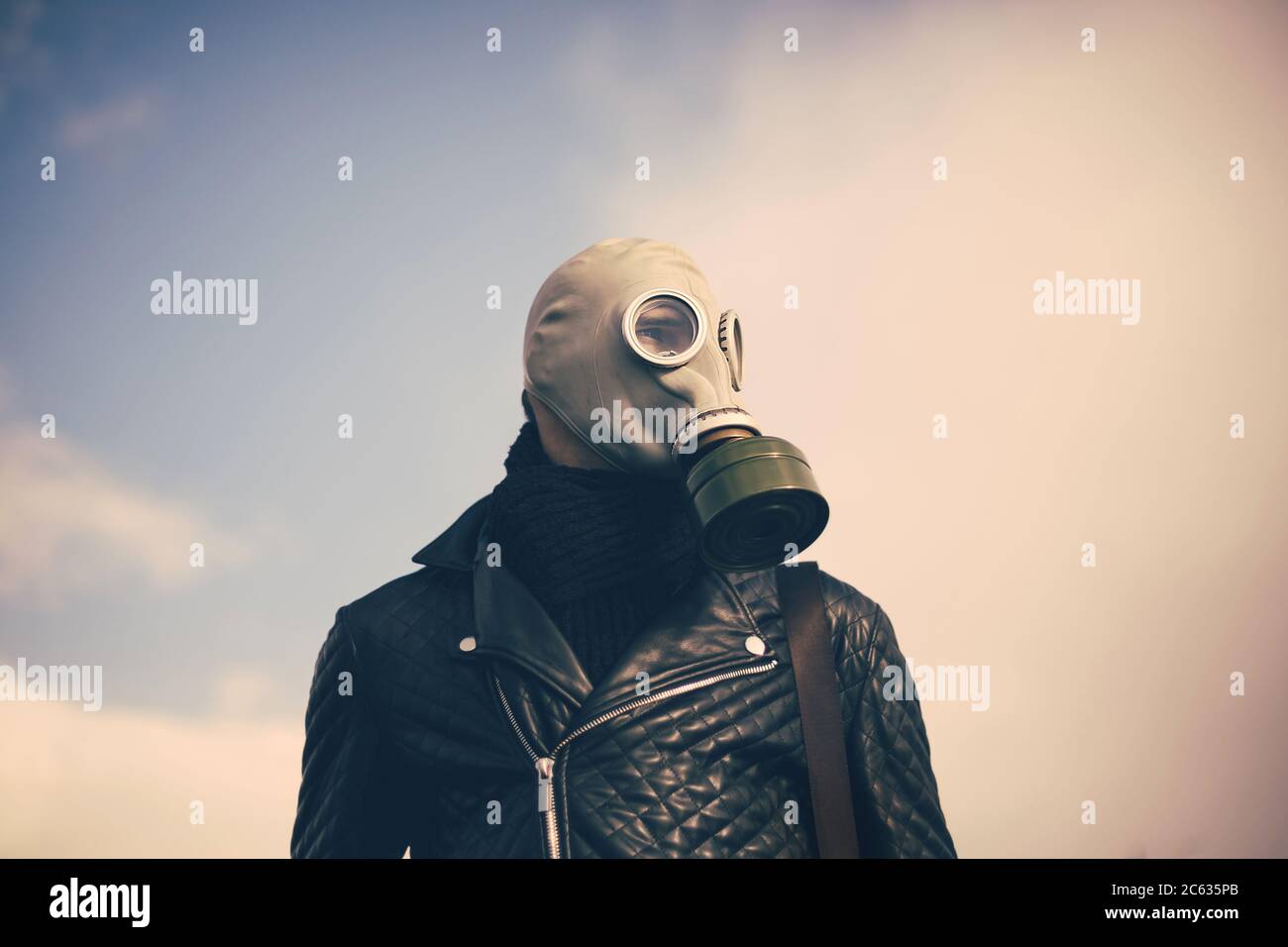Male scientist in a gas mask while putting on rubber glove in ...