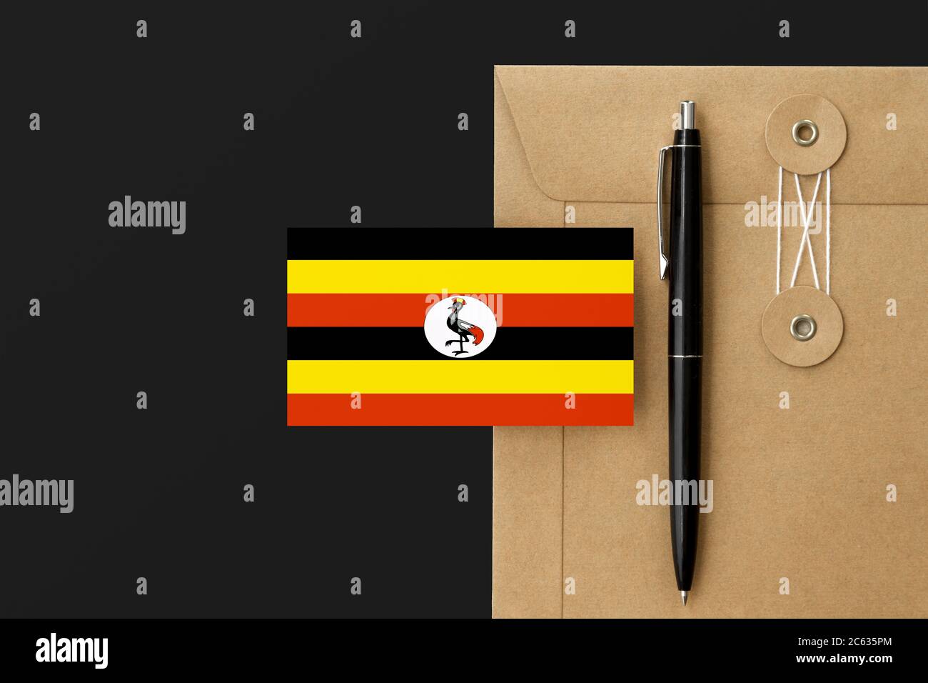 Uganda flag on craft envelope letter and black pen background. National ...
