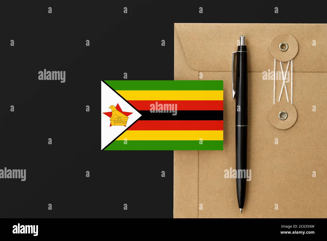 Zimbabwe flag on craft envelope letter and black pen background ...