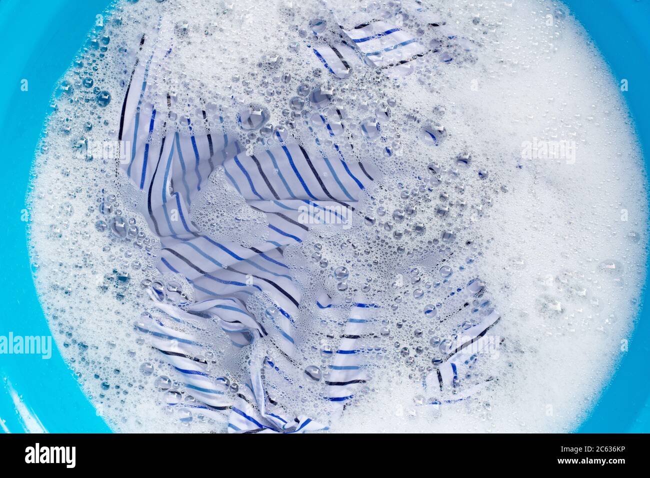 Clothes soak in powder detergent water dissolution. Laundry concept ...