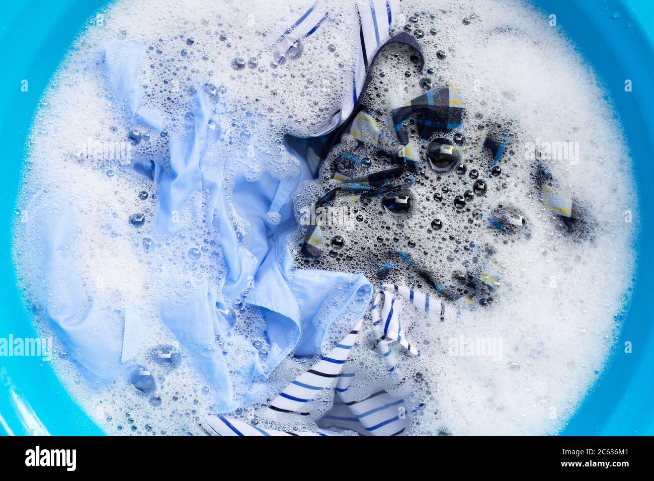 Top view of clothes soak in powder detergent water dissolution. Laundry ...
