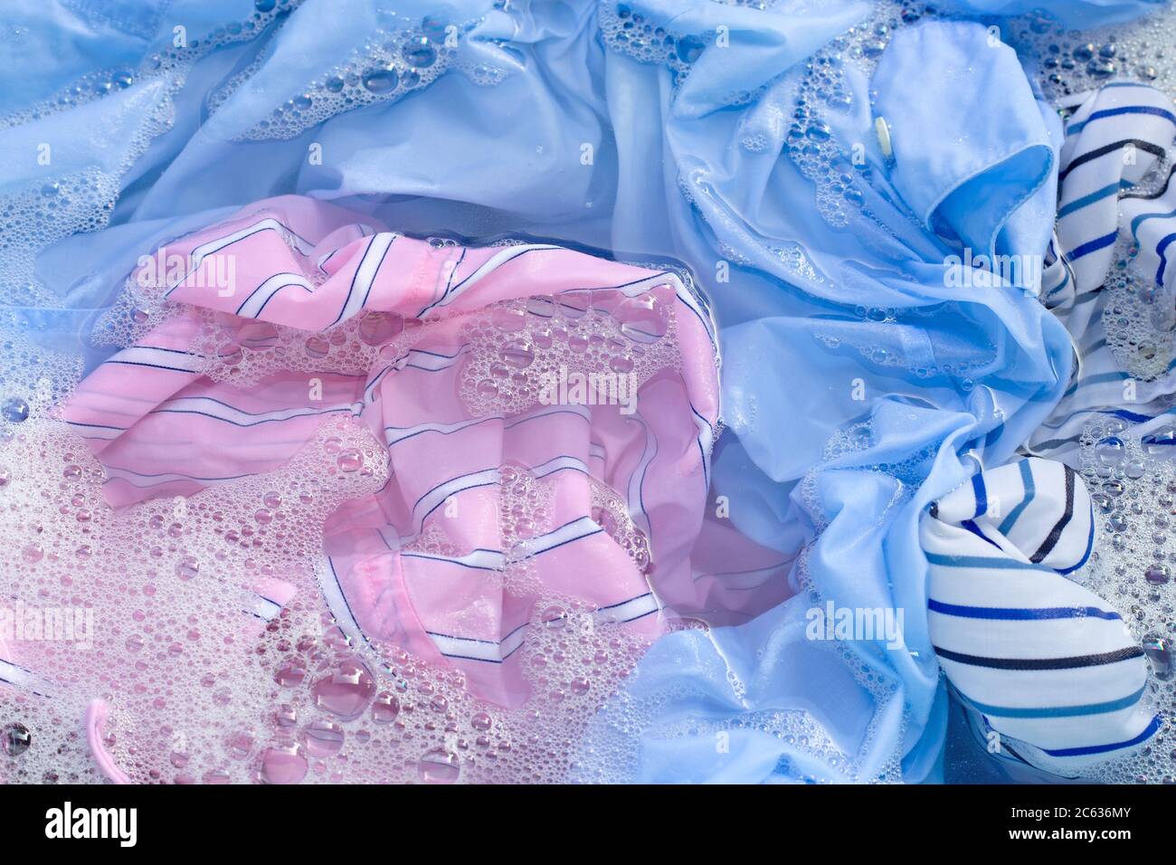 Top view of color clothes soak in powder detergent water dissolution ...