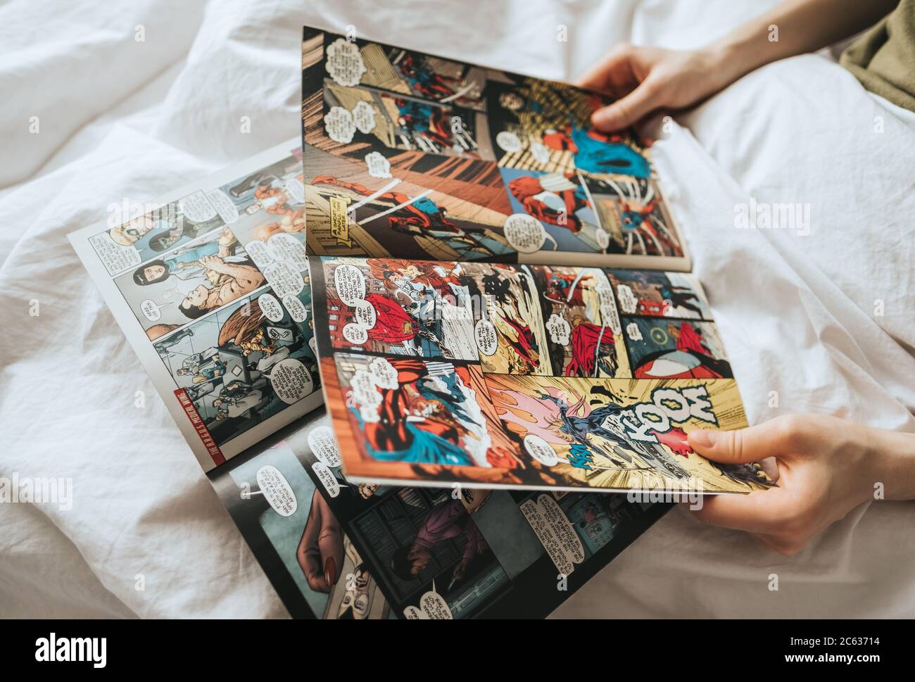 Woman reads comics in bed Stock Photo - Alamy