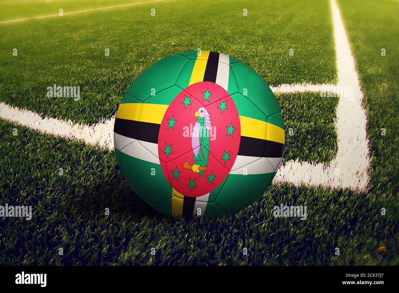 Dominica flag on ball at corner kick position, soccer field background ...