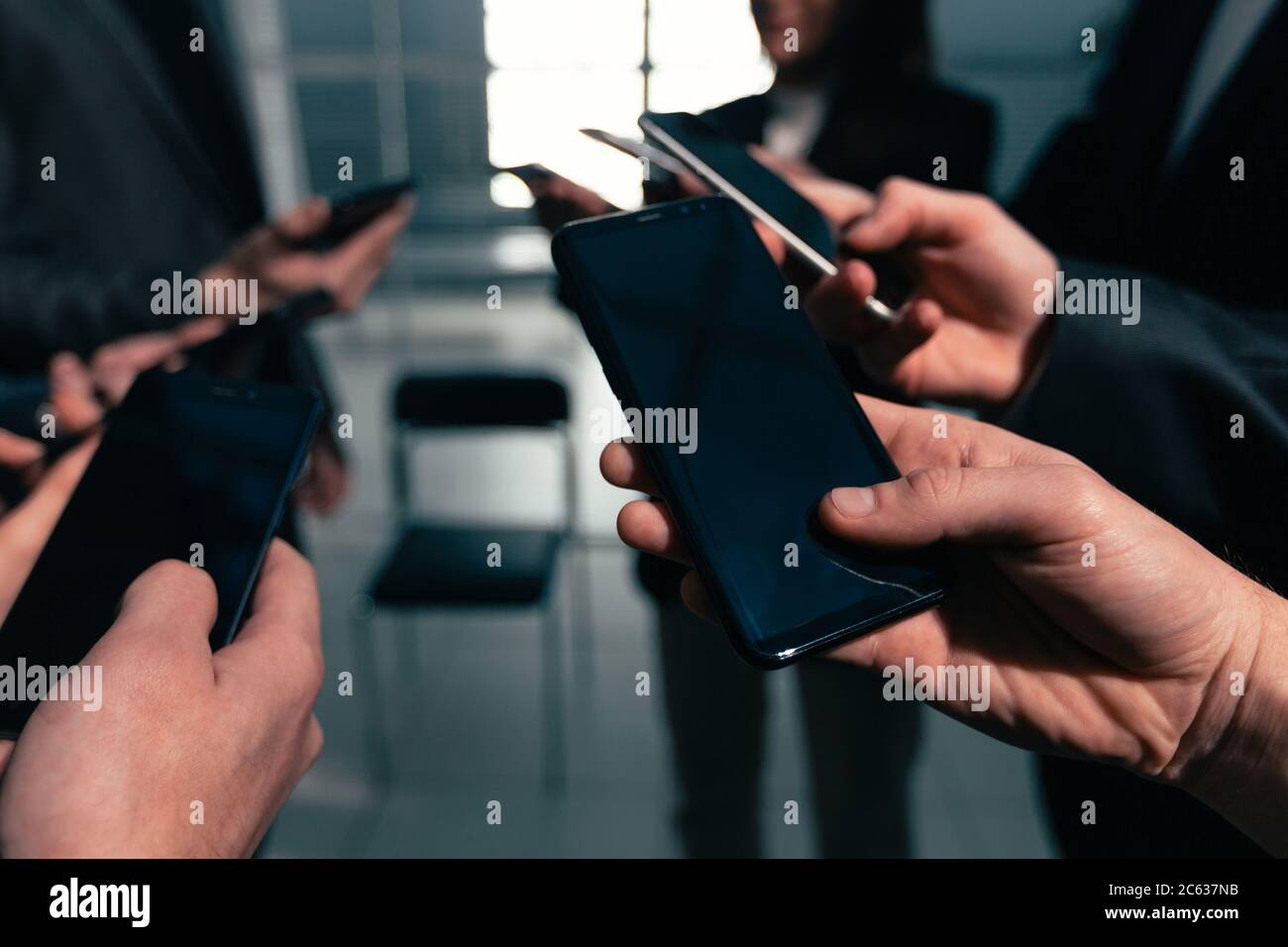 close up . young business people looking at their smartphone screens ...