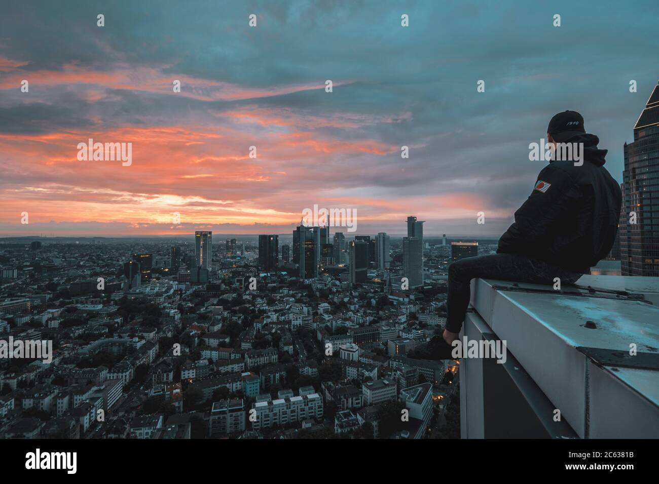Circa June 2018: Person Sitting on Rooftop edge overlooking Cityscape ...