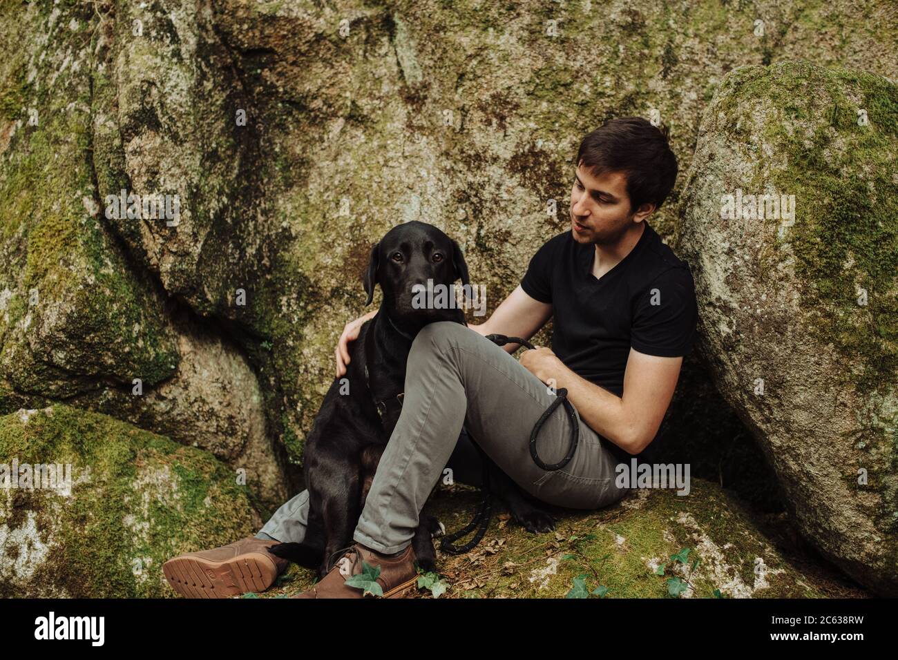 Man sitting on rock with dog hi-res stock photography and images - Alamy