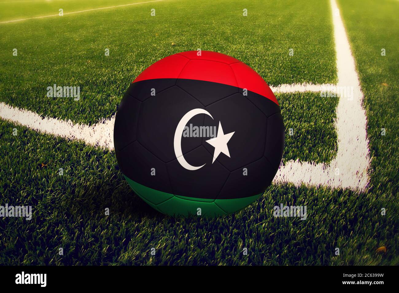 Libya flag on ball at corner kick position, soccer field background ...
