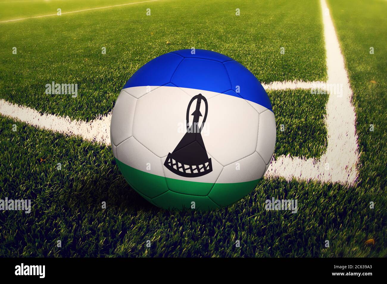 Lesotho flag on ball at corner kick position, soccer field background ...