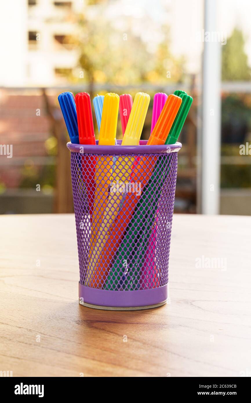 Colored markers inside a basket of pens Stock Photo - Alamy