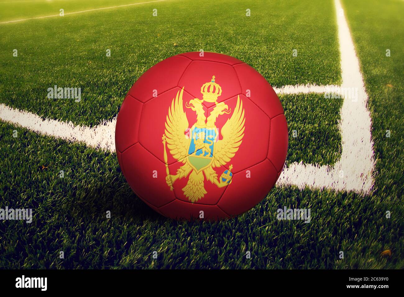 Montenegro flag on ball at corner kick position, soccer field ...