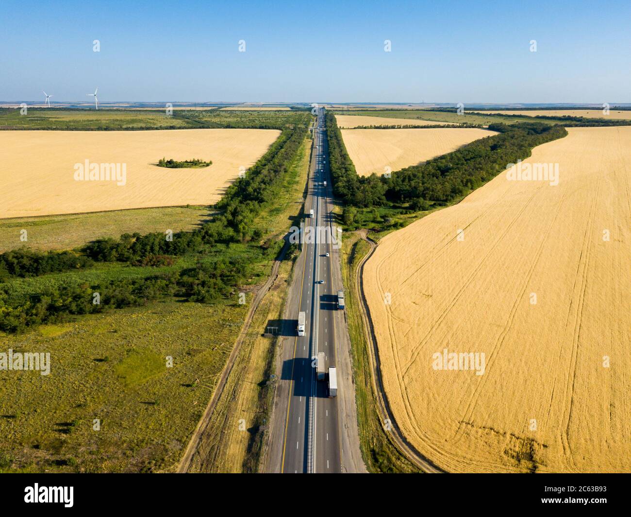 Left hand driving motorway with speedy cars surrounded by green rural ...