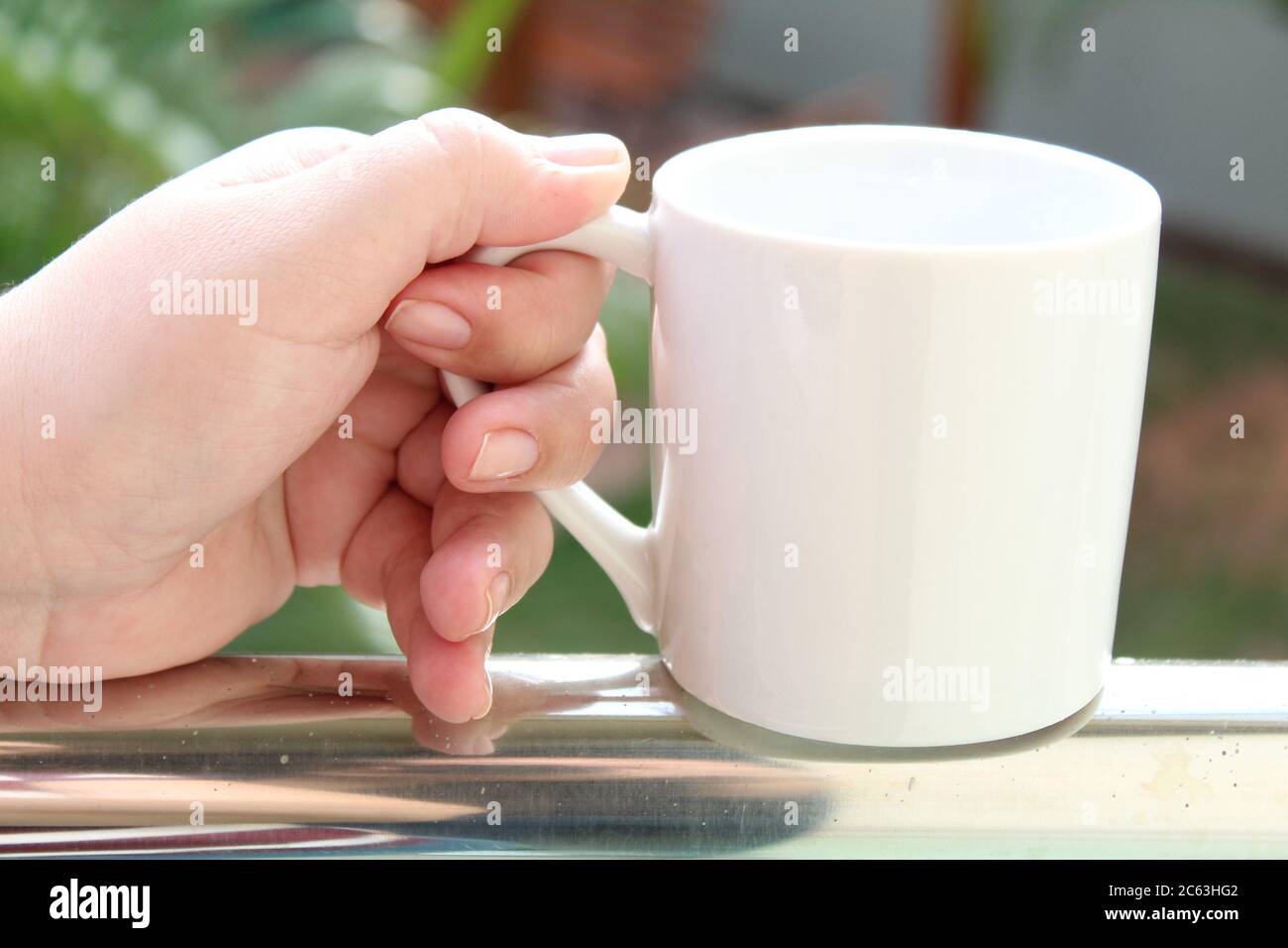 Hand and mug Stock Photo - Alamy