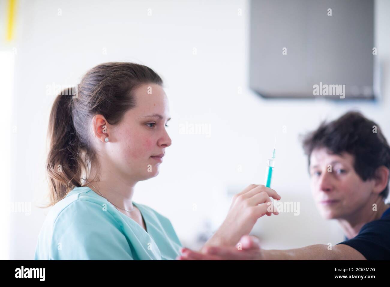 nurse with syringe and a patient female Stock Photo - Alamy