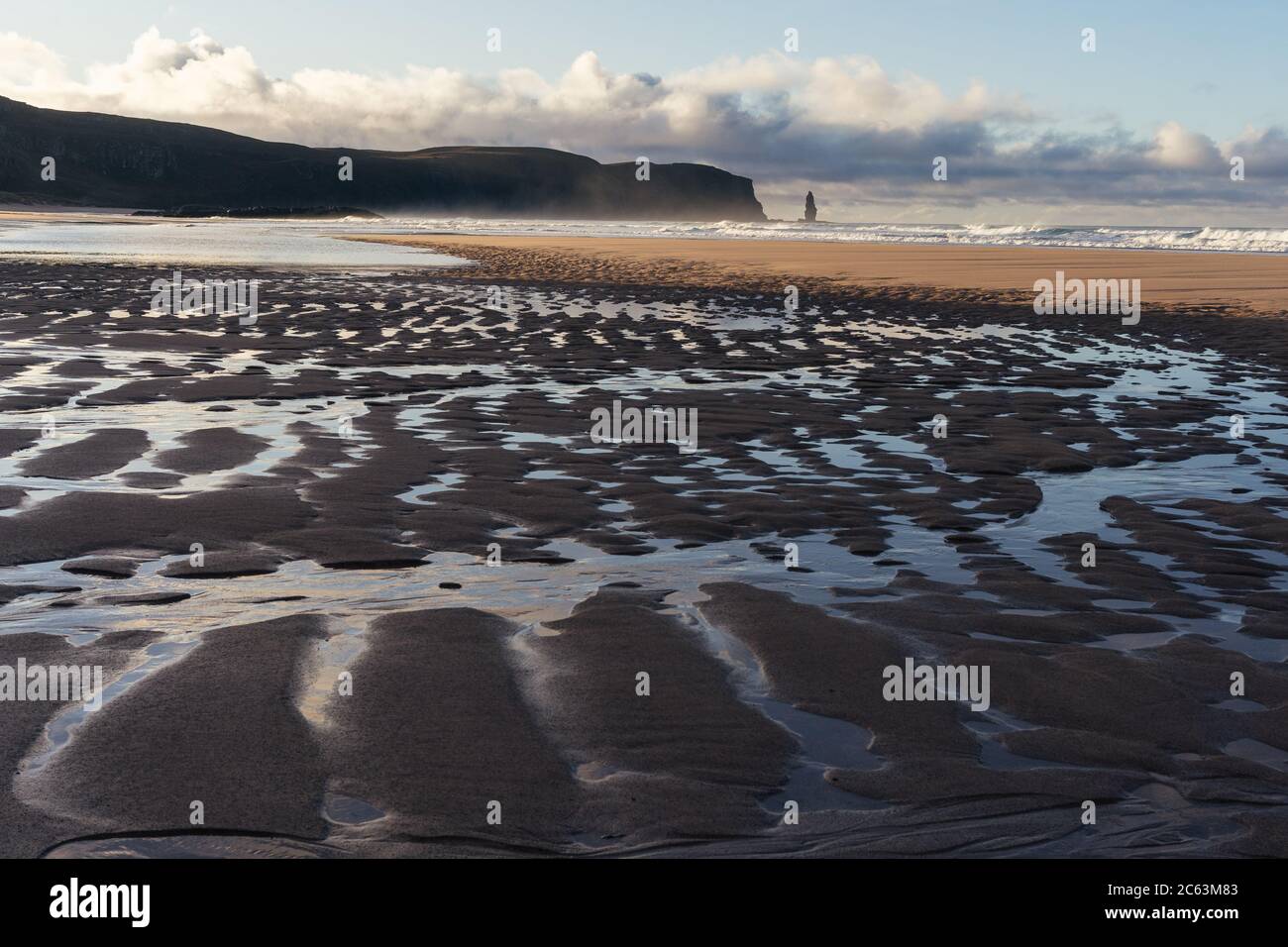 Sandbar at sunset with sea stack and waves crashing Stock Photo - Alamy