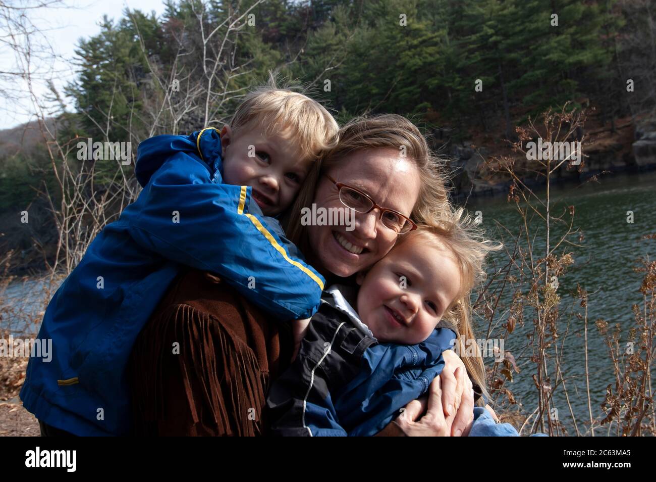 Two loving children embracing their mom on a string walk Stock Photo ...