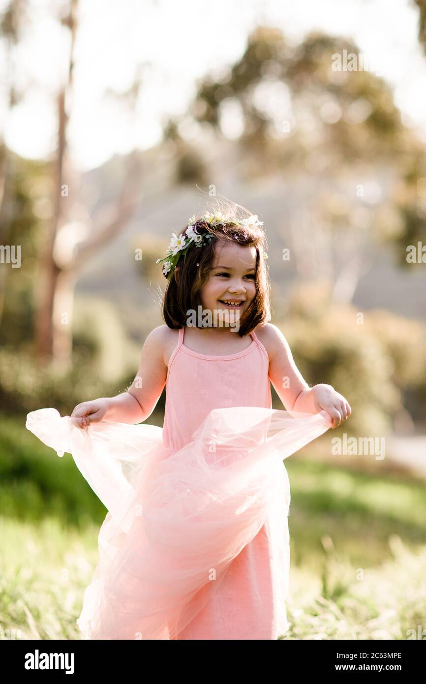 Young girl in tutu and flower crown standing in field, smiling Stock ...