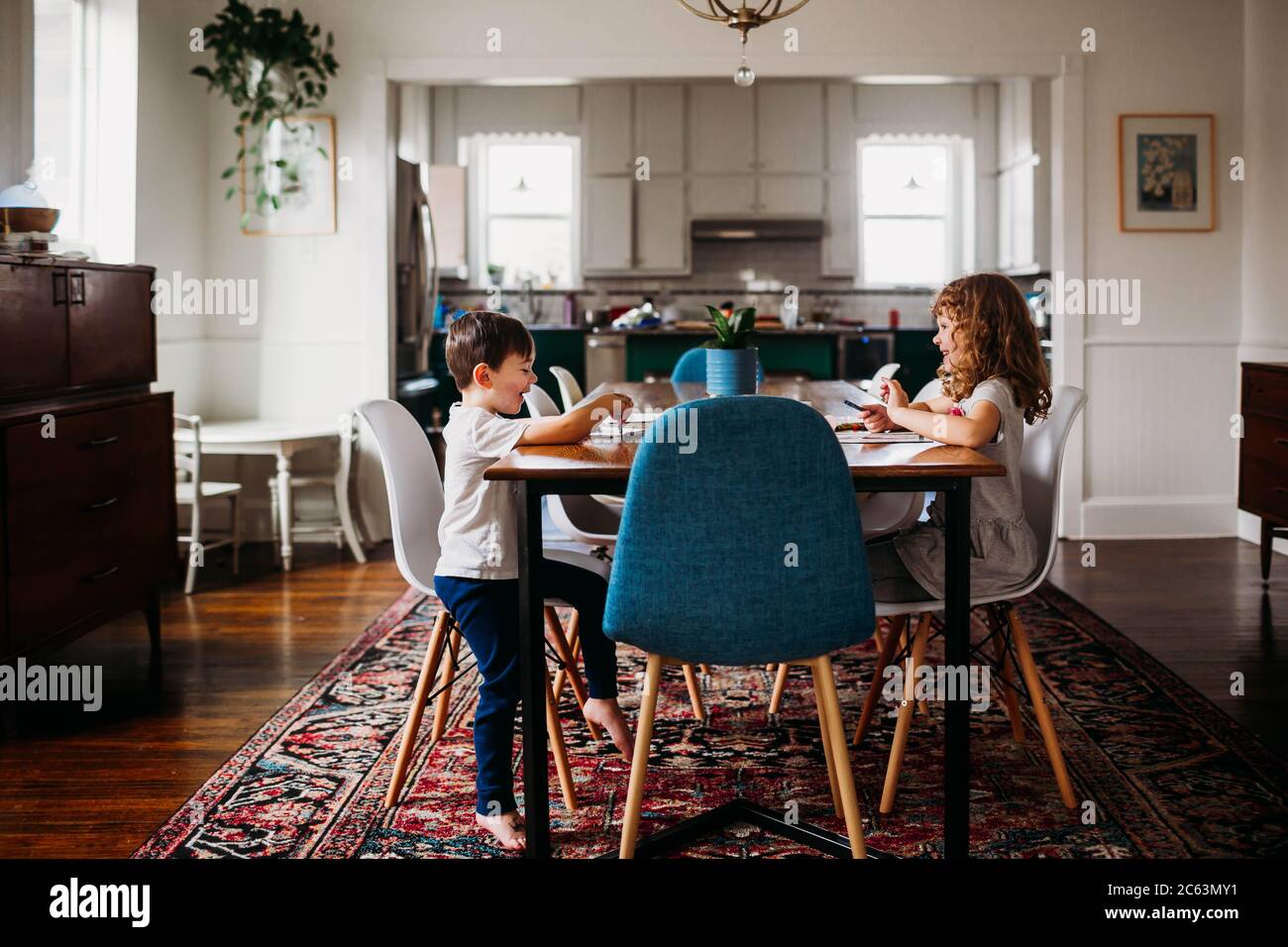 Young kids sitting at dining table doing arts and crafts together Stock ...